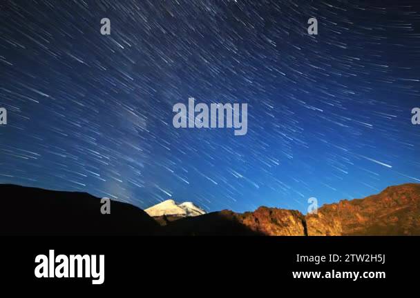 stars draw fading lines over Elbrus mountain. Night landscape. Russia ...