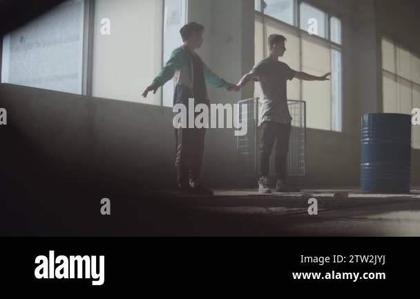 Two men dancing in the dark and dusty room of abandoned building ...