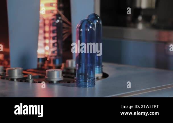 PET preforms move on heating oven line in fast speed. Plastic bottles ...