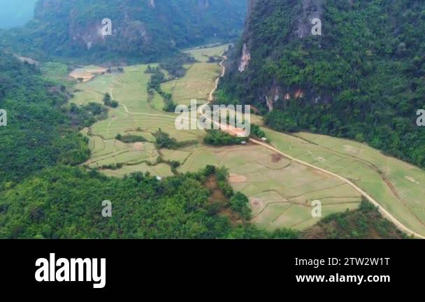 Aerial: flying over scenic cliffs rock pinnacles tropical jungle rice ...