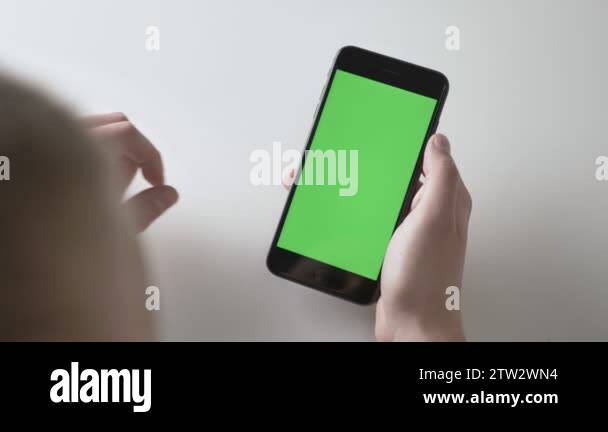 Mens hands hold a big black smartphone making pinch to zoom gesture ...
