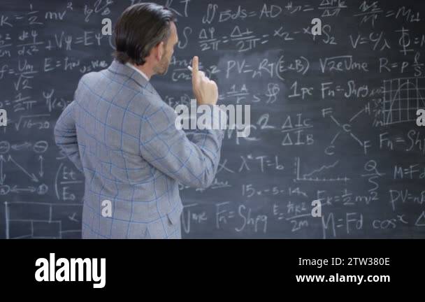 4K Portrait smiling academic man studying math formulas on blackboard ...