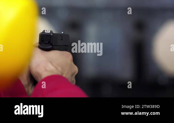 Back view of man shoots a gun at shooting range close up. Man fires ...