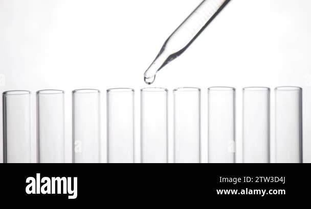 Pipette drips clean chemicals into a test tubes on white background ...