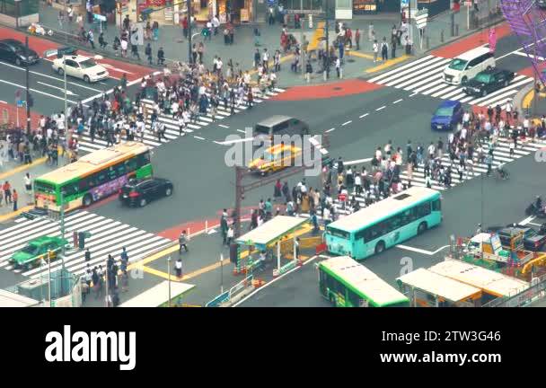 People cross the famous intersection in Shibuya, Tokyo, Japan one of ...
