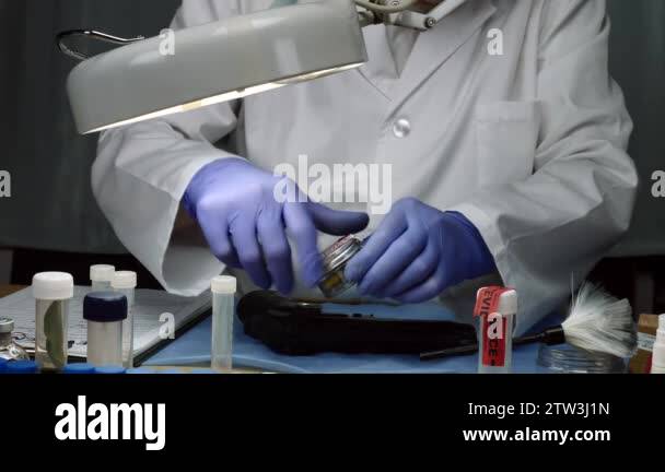 Scientific police officer examining traces of a gun in ballistic ...