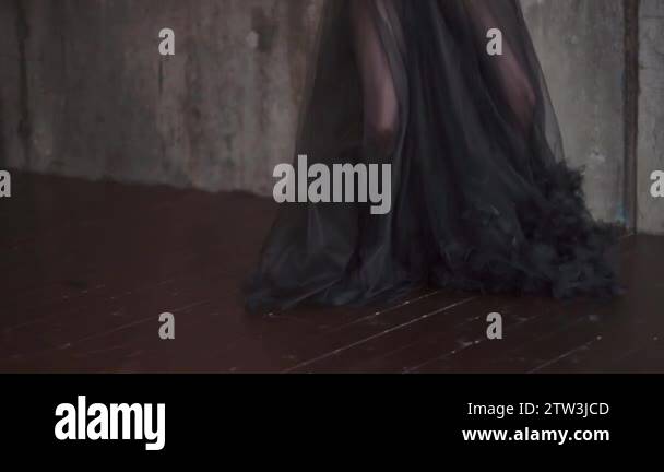 Ballerina in a training class is rehearsing dancing steps and hands ...