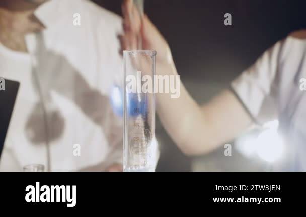 Woman scientist mixing together two liquid substances. Experiments in a ...