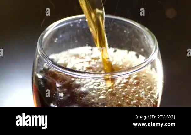 A drink of Coca Cola is poured into a glass. Bubbles of carbonated beverage Stock Video Footage ...