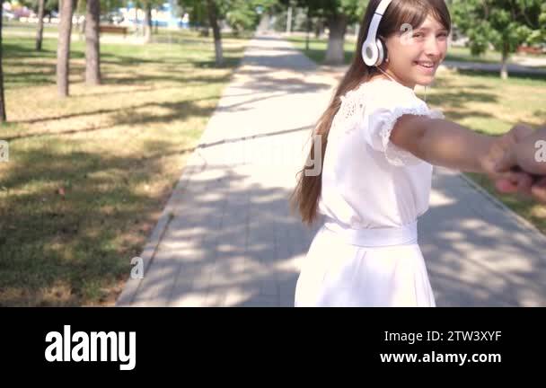 come after me.girl in headphones smiles and leads the beloved man by ...