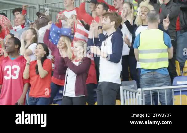 4K Excited fans with US flag in sports crowd, clapping and cheering on ...