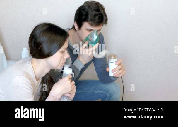 Use nebulizer and inhaler for the treatment. Man and woman inhaling ...