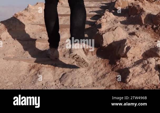 Male legs climbing up on desert stairs. Slow motion. Man steps on ...