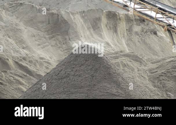 Sand falling in a sand mountain by a conveyor in a sand and pebbles ...