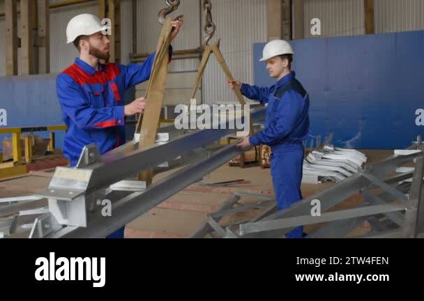 Workers at the plant load the cargo onto the hook of the crane against ...