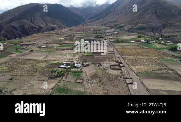Aerial flying above little farms with crops on mountain slopes ...
