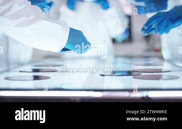 Scientific research team wearing full body suits examining hi-tech ...