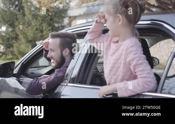 Portrait little girl on the back seat of the car leaned out of the ...