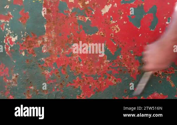 Rust removing from old metal plate using wire brush, closeup oh hand ...