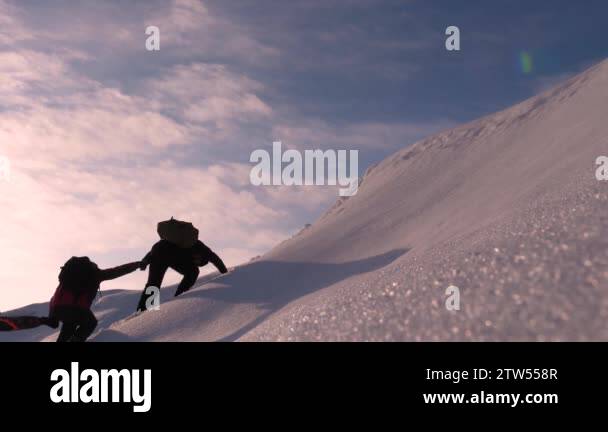 travelers hand in hand in winter go to their victory overcoming ...