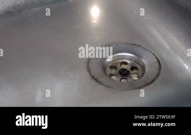 Water drop dripping down the drain, deep sinkhole, background loop ...
