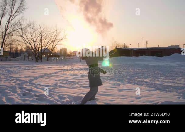 Converting hot water into steam, extreme cold -30 -35 degrees. The girl ...