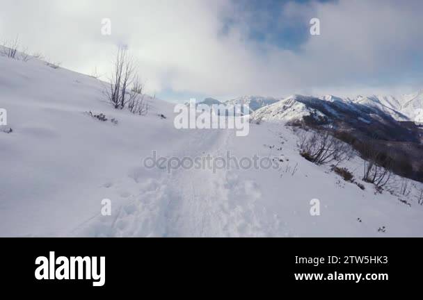 Forward POV hiking and walking with snowshoes outdoor on white snowy ...