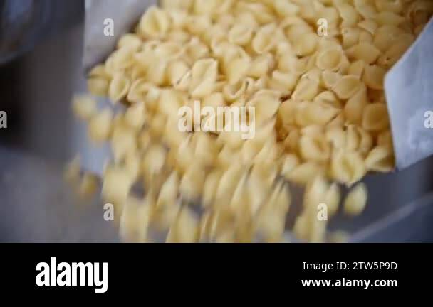 Dropping macaroni from a conveyor belt at the pasta factory - slow ...