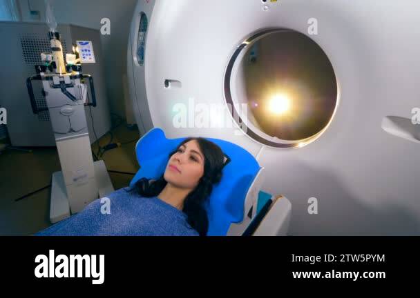Young girl on a magnetic resonance imaging MRI scanner in a modern ...