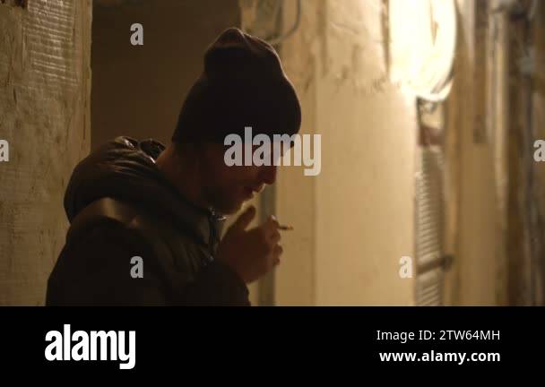 Young Guy Smoking Hand Rolling Tobacco CIgarette in House Gateway, Cold ...