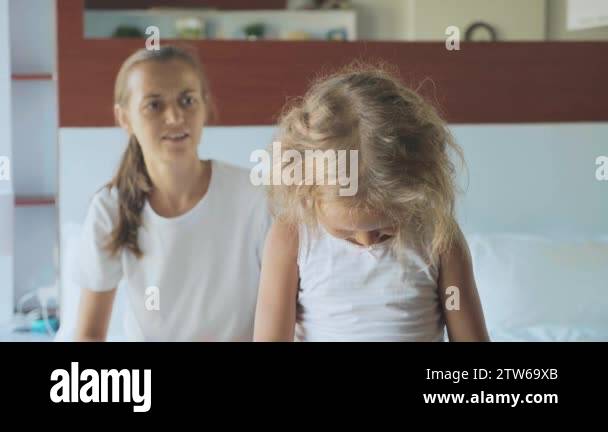 Angry mother scolding her daughter while sitting on the bed in bedroom at home Stock Video ...