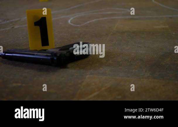 Cinematic camera move past 9mm handgun with evidence marker at active ...