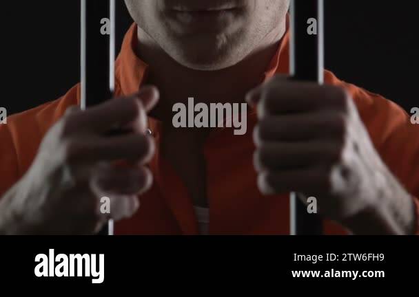 Cruel serial killer holding jail cell bars, prisoner hands closeup, law ...