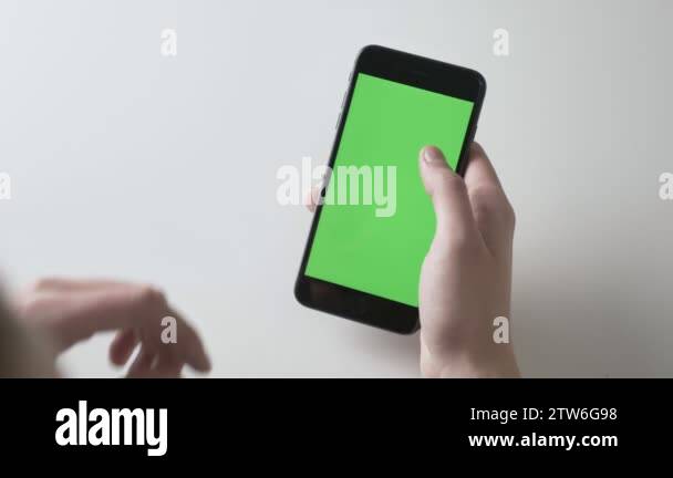 Mens hands hold a big black smartphone making pinch to zoom gesture ...