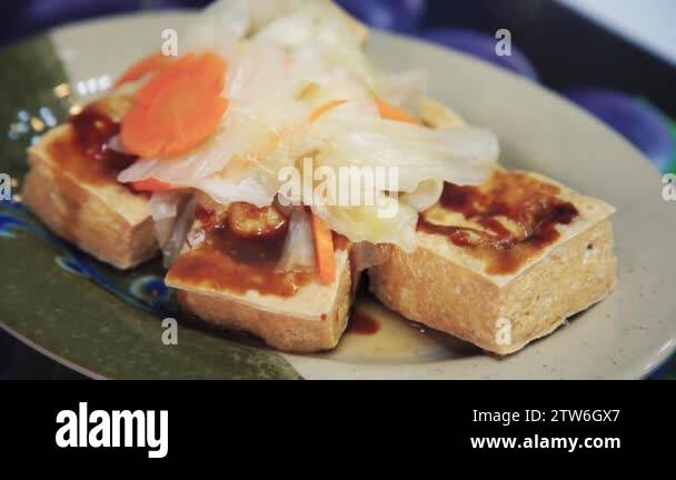 Fried stinky tofu serve on plate with plastic. Famous and iconic ...