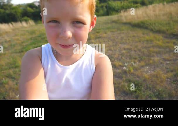 Handsome baby looking with interest to the camera that he holds in his ...