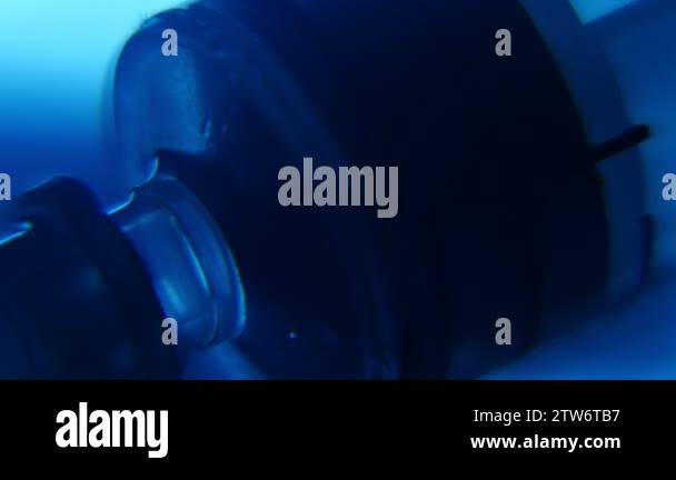 Crystal clear water is pulled in a plastic syringe in blue pharmacy ...