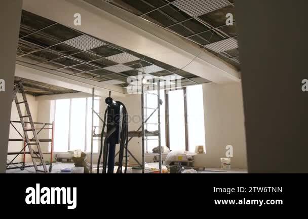 Installing metal profile ceiling during the repair in the living room ...