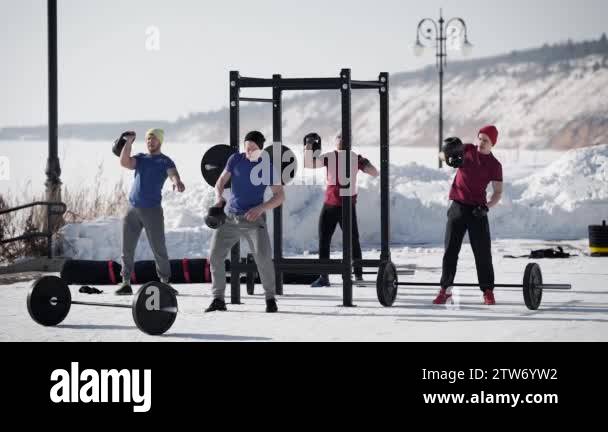 young and strong guys go in for sports on the street on a winter day ...