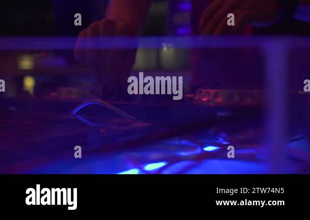 DJ console for mixing dance music and colorful light in disco club. DJ ...