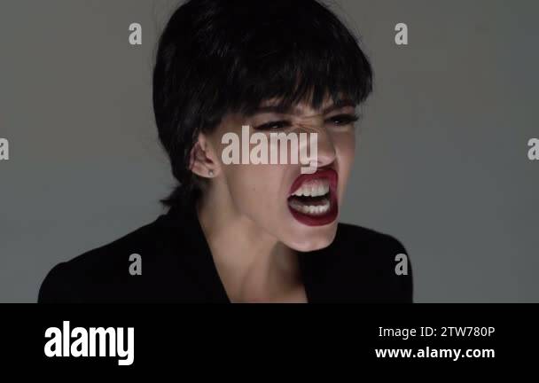 Portrait of pretty girl with red lips shouting. Face of angry woman ...