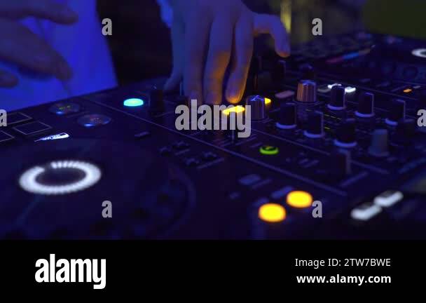 DJ console for mixing dance music and colorful light in disco club. DJ ...