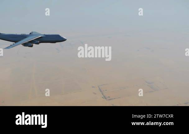 Side view of big military air freighter plane flying above mideast or ...