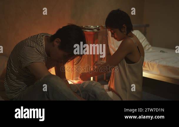 4K Drug addict couple in gloomy apartment injecting drugs and passing ...