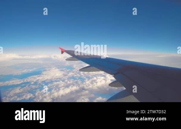 Airplane flight. Wing of an airplane flying above the clouds. View from ...