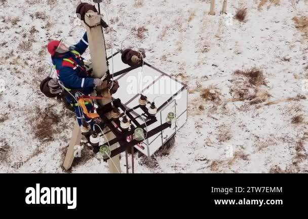 Man working at electric station and repair energy line on the tower ...