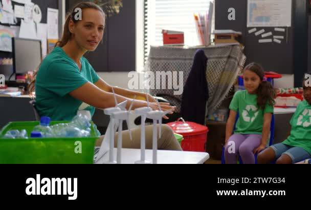 Side view of Caucasian female teacher teaching schoolkids about green ...