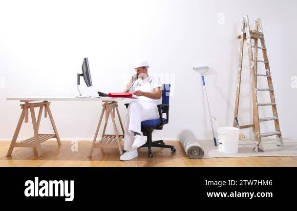 house painter man with a computer talk on the phone, looks at color ...