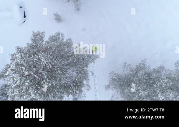 AERIAL: Flying above unrecognizable person wading through fresh snow ...
