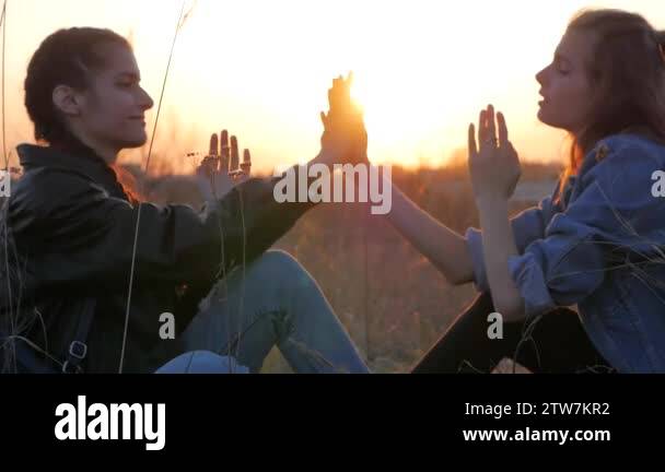 two girls playing hand clapping game outdoors sunset background. summer ...
